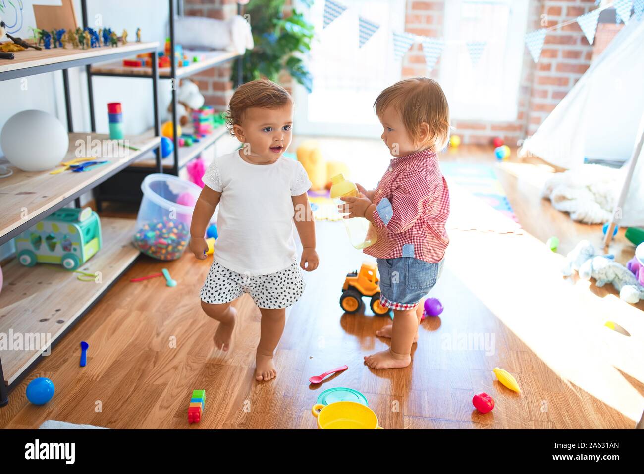 Adorable toddlers playing around lots of toys at kindergarten Stock ...
