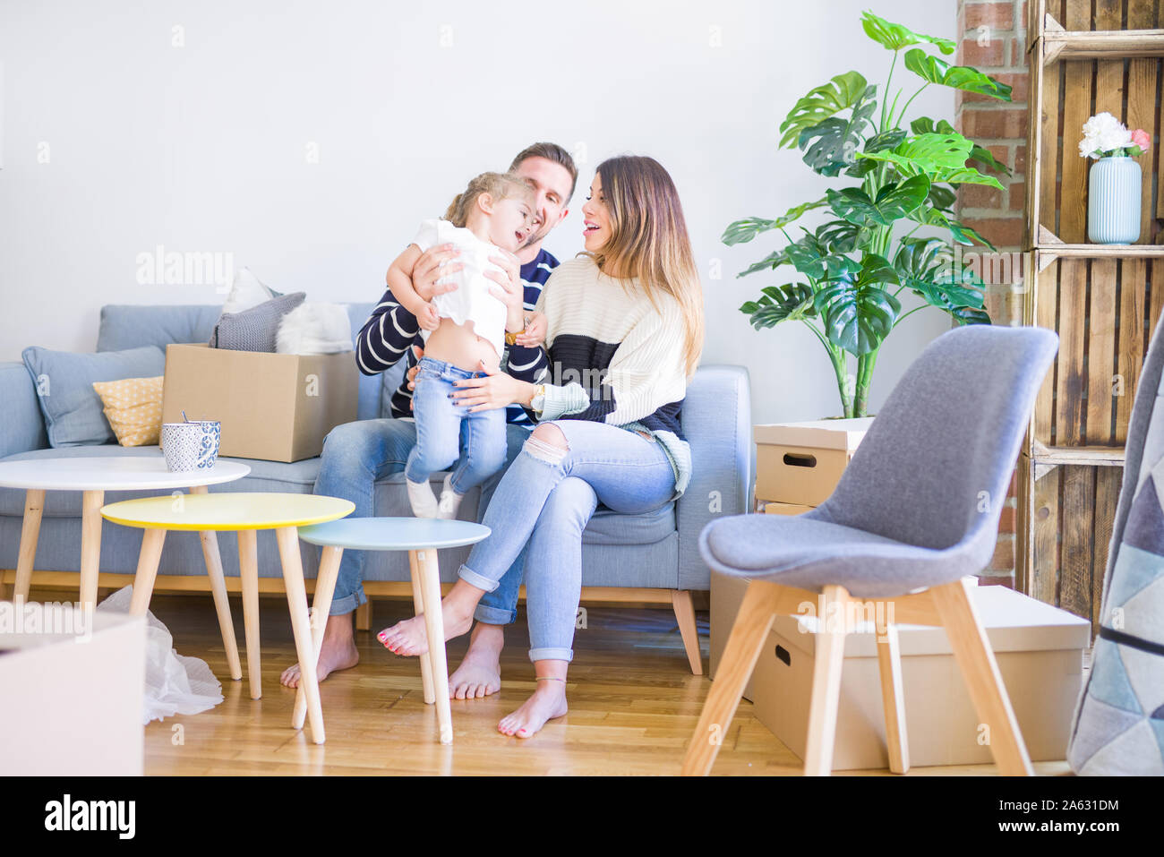 Beautiful family, parents sitting on the sofa drinking coffee looking ...