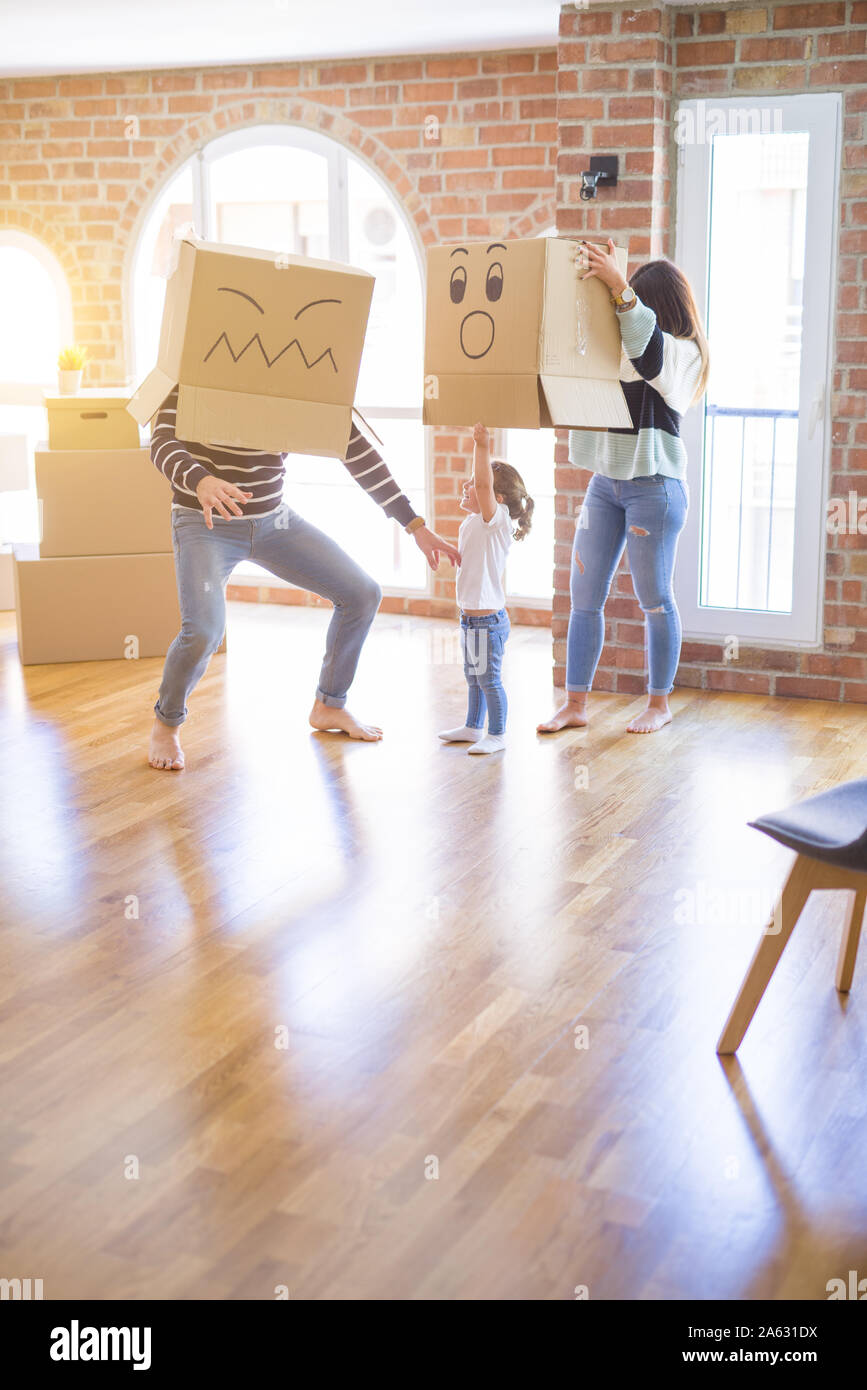 Beautiful famiily with kid playing with cardboard fanny boxes at new ...