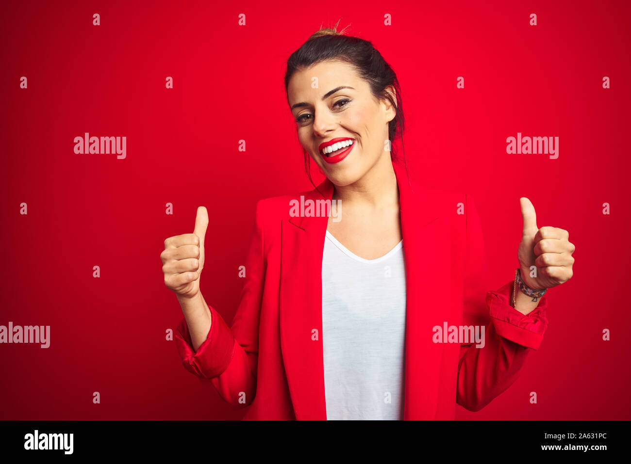 Young beautiful business woman standing over red isolated background ...