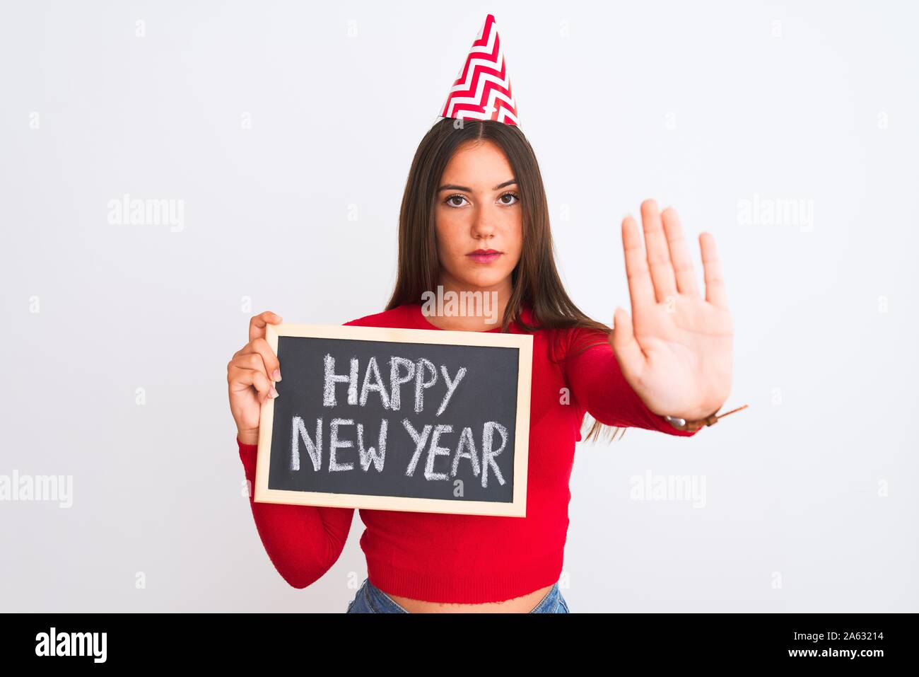 Beautiful girl wearing fanny party hat holding blackboard over isolated ...