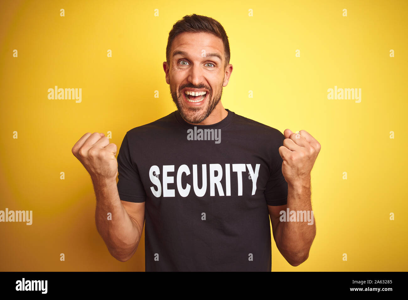 Young safeguard man wearing security uniform over yellow isolated ...