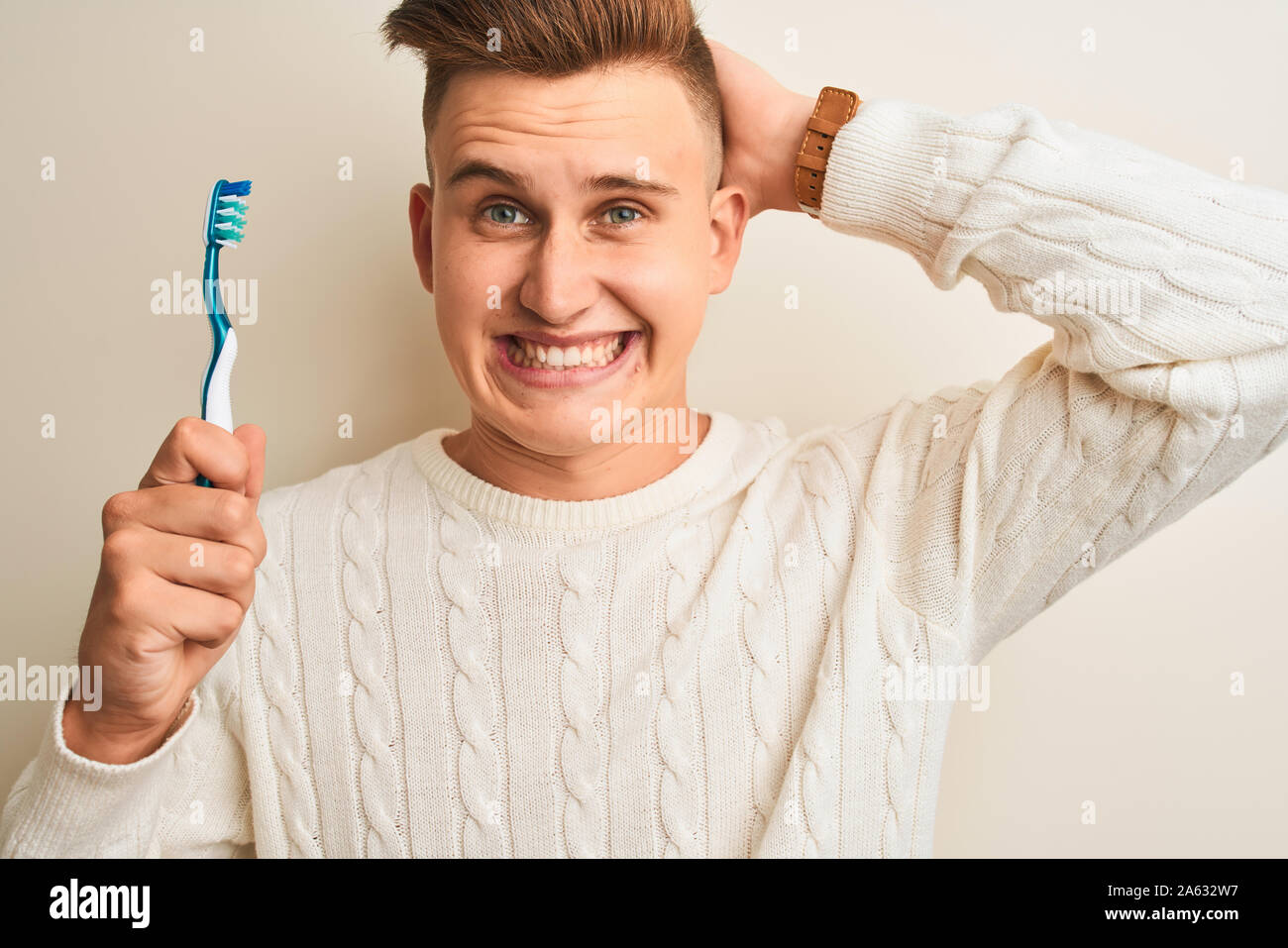 Young handsome man holding tooth brush standing over isolated white ...