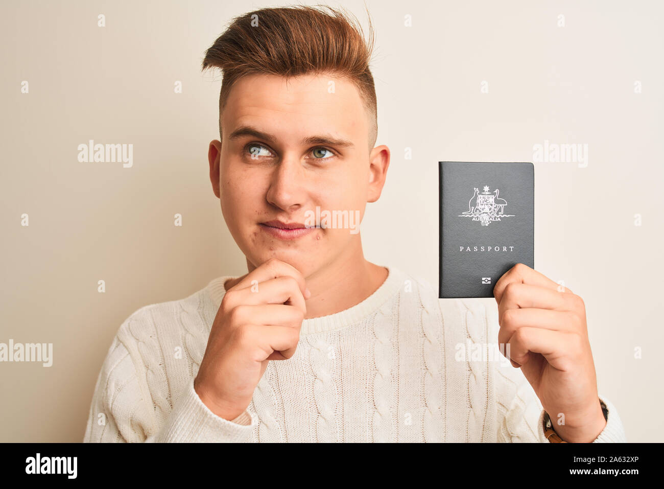 Young handsome man holding Australia Australian passport over isolated ...