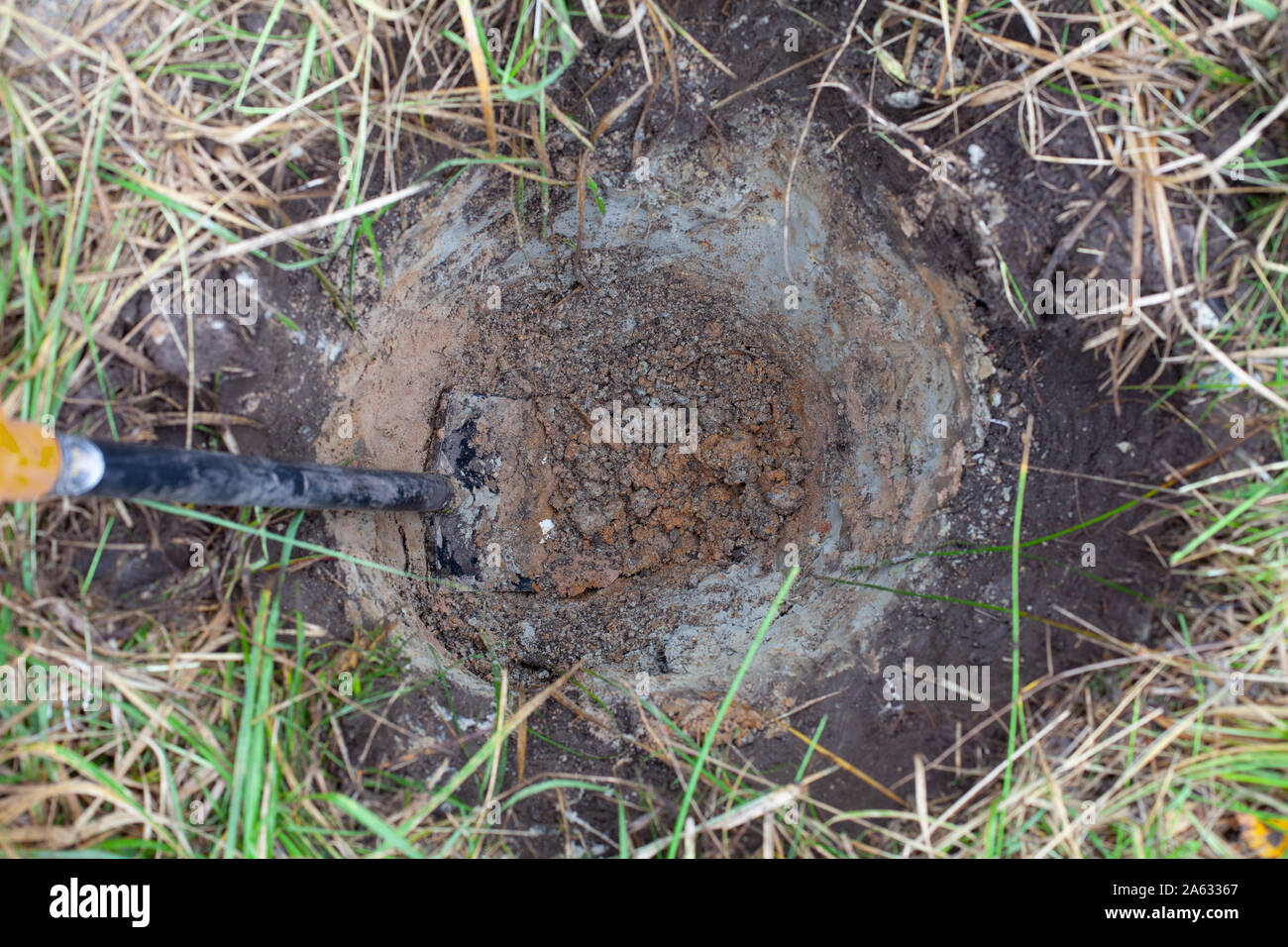 Digging a deep pit with shovel for replanting plants in a better soil ...