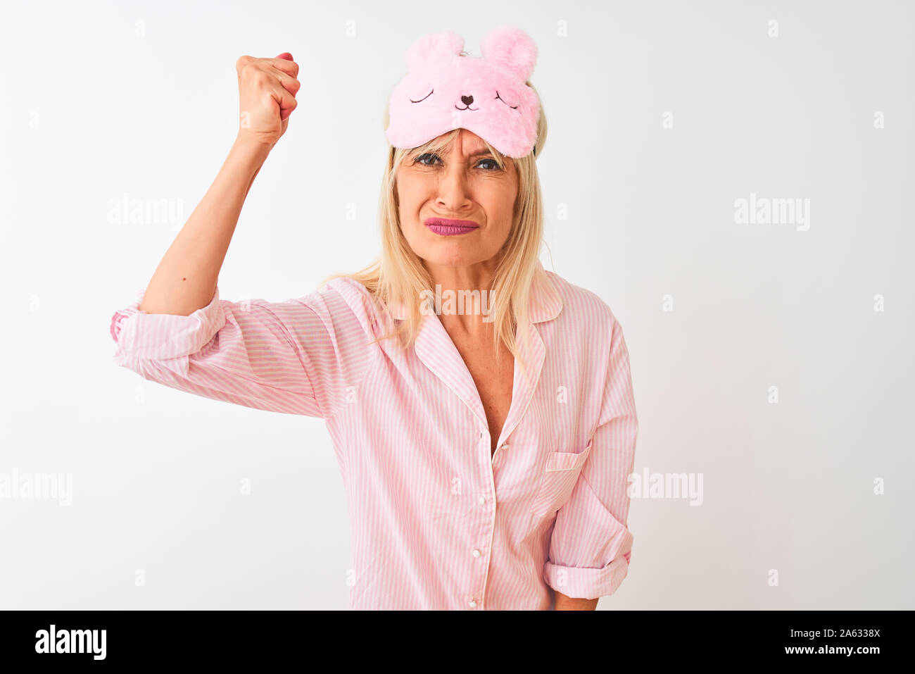 Middle age woman wearing sleep mask and pajama over isolated white ...