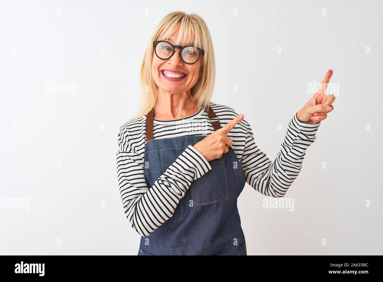 Middle age woman wearing apron and glasses standing over isolated white ...