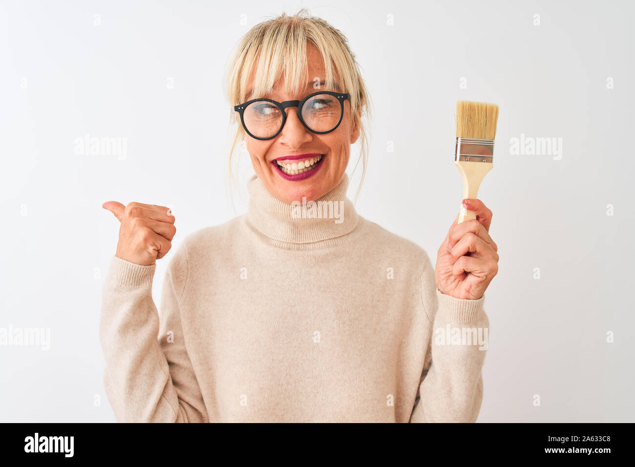 Middle age painter woman holding paint brush standing over isolated ...