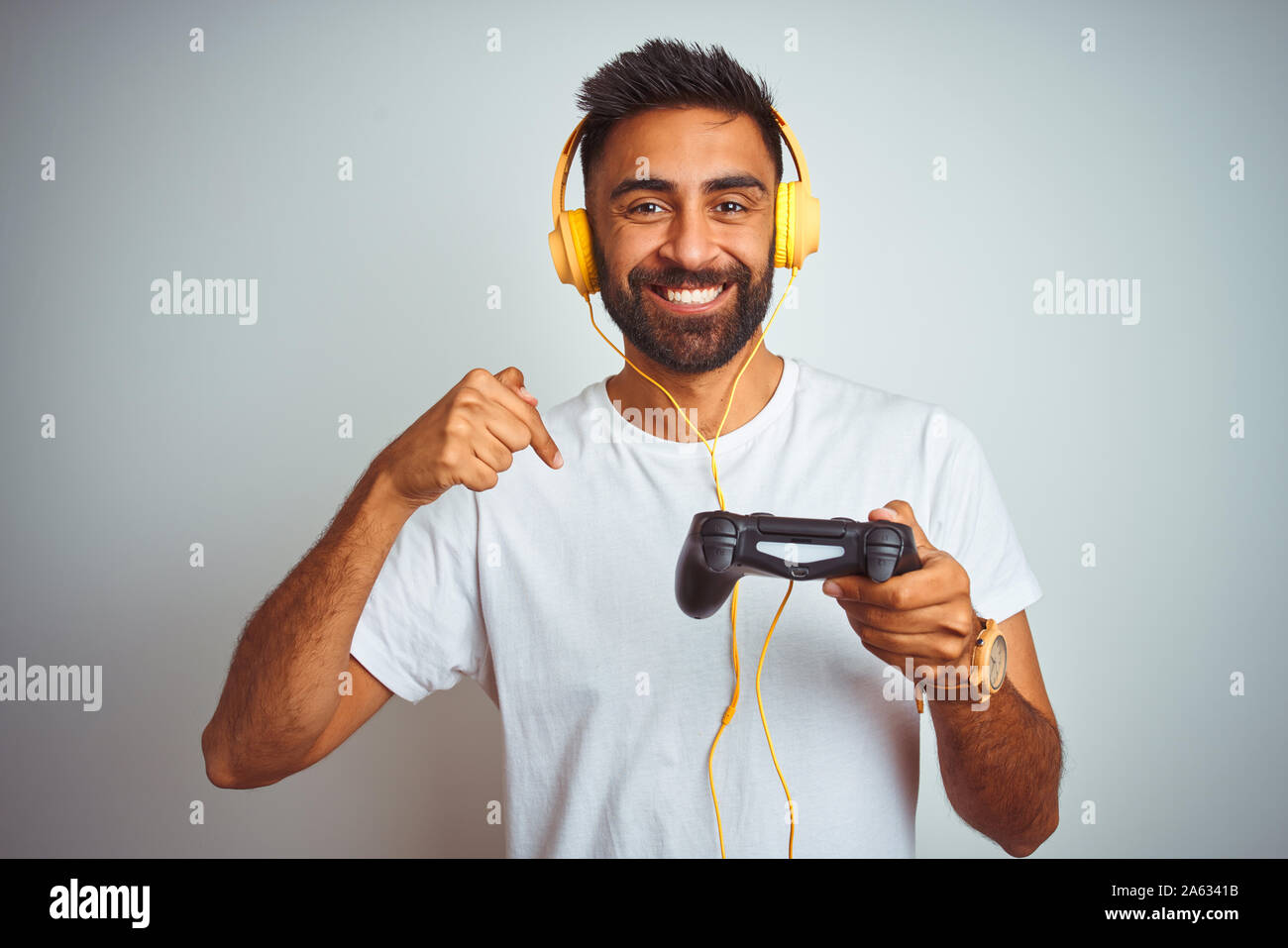 Arab indian gamer man playing video game using headphones over isolated ...