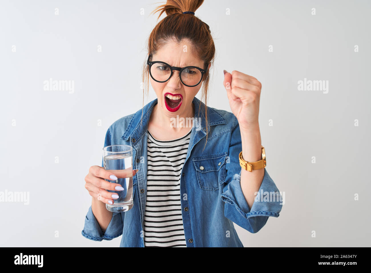 Young beautiful redhead woman drinking glass of water over isolated ...