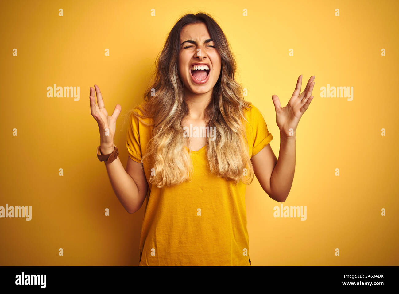 Young beautiful woman wearing t-shirt over yellow isolated background ...