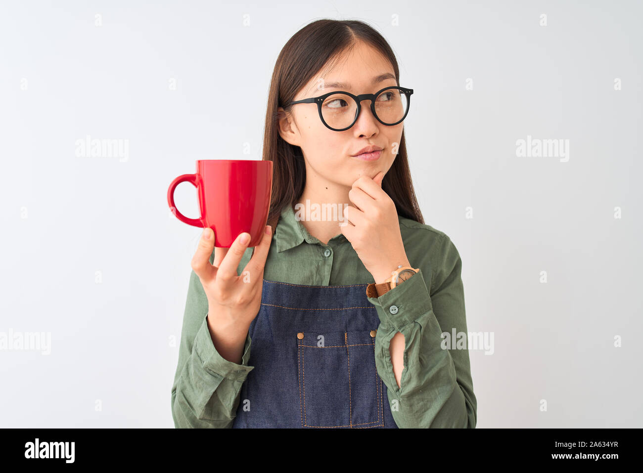 Chinese barista woman wearing apron glasses drinking coffee over ...