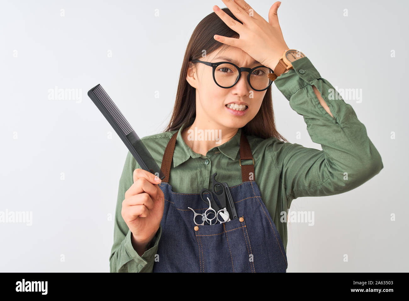 Chinese hairdresser woman wearing glasses holding comb over isolated ...