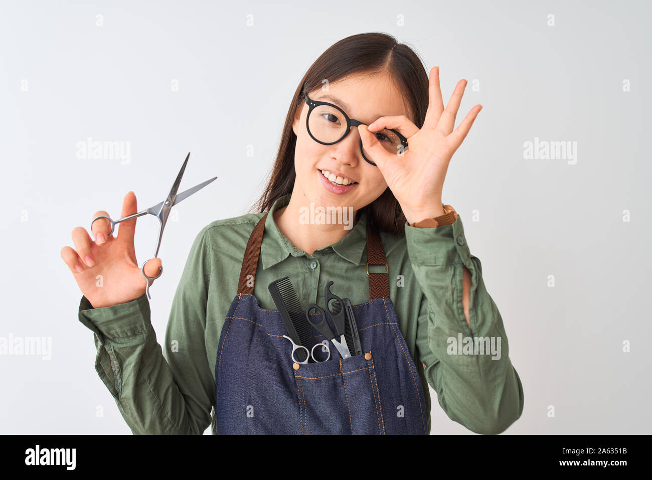 Chinese hairdresser woman wearing glasses holding scissors over ...