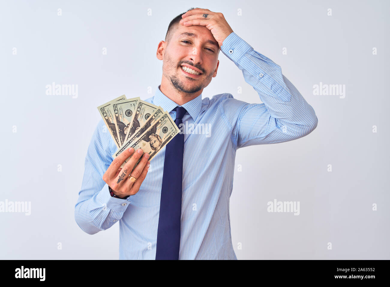 Young handsome business man holding a bunch of bank notes dollars over ...