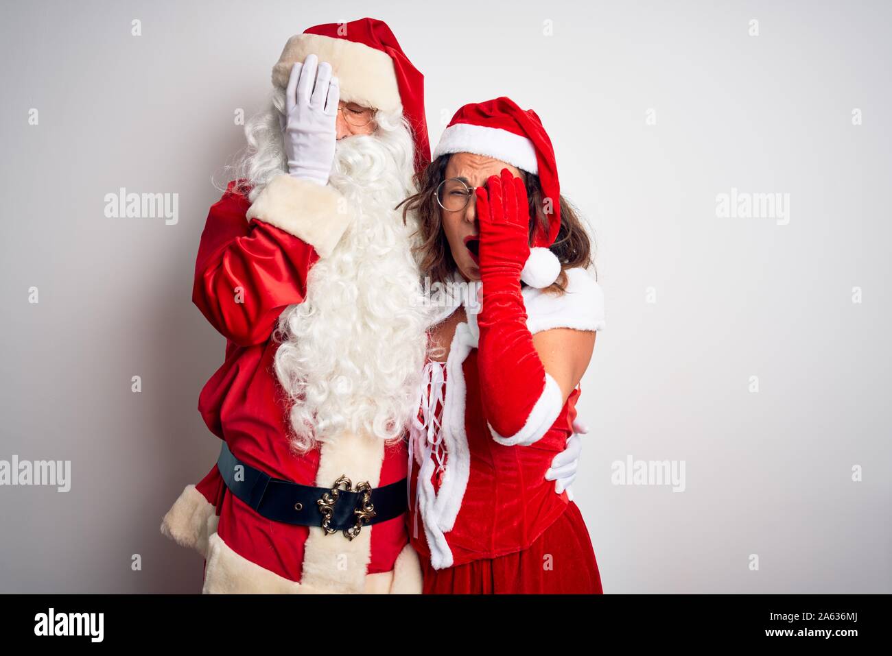 Middle age couple wearing Santa costume hugging over isolated white ...