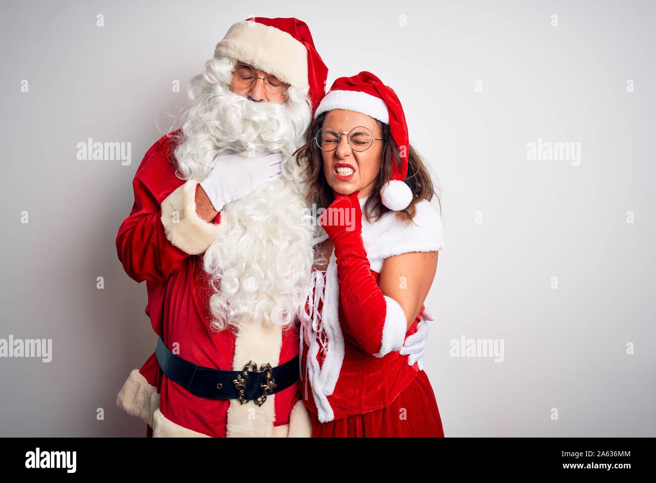 Middle age couple wearing Santa costume hugging over isolated white ...