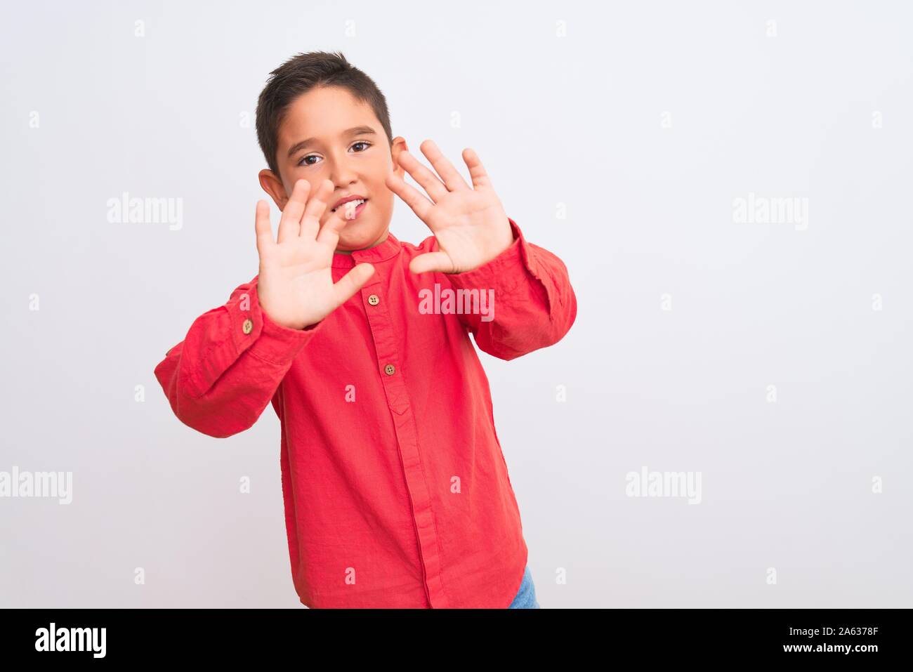 Beautiful kid boy wearing elegant red shirt standing over isolated ...