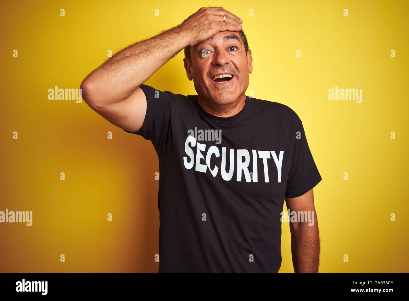 Middle age safeguard man wearing security uniform over isolated yellow ...