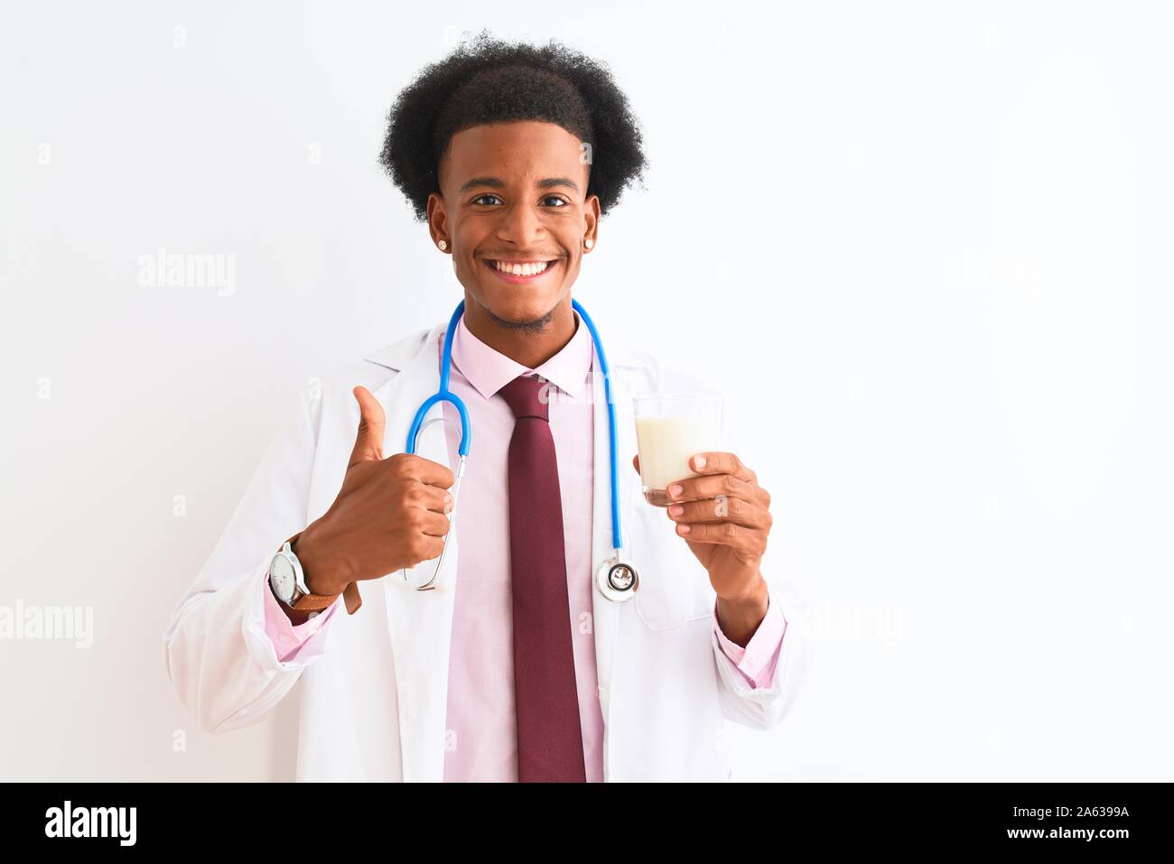 Young african american doctor man drinking glass of milk over isolated ...