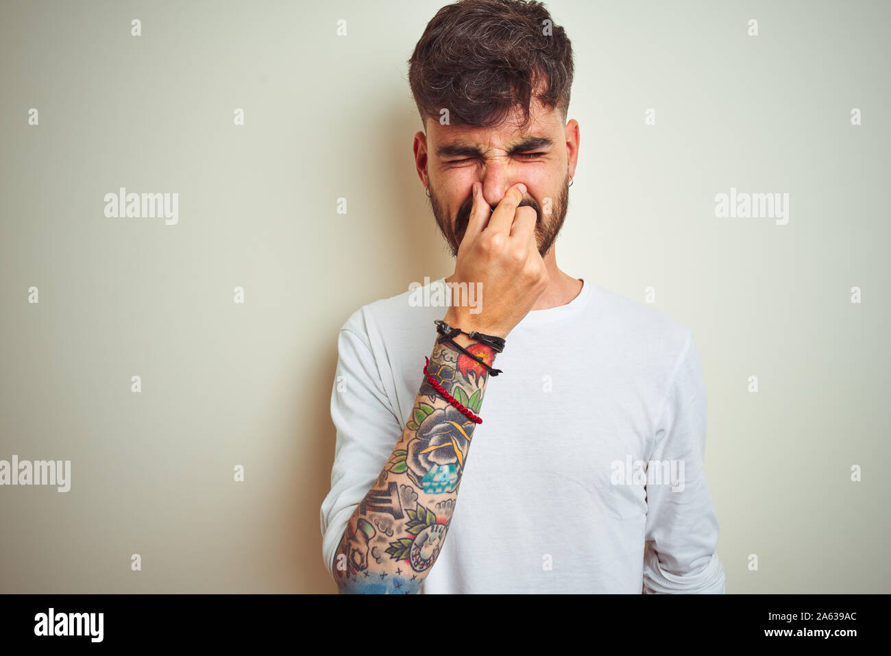 Young man with tattoo wearing t-shirt standing over isolated white ...