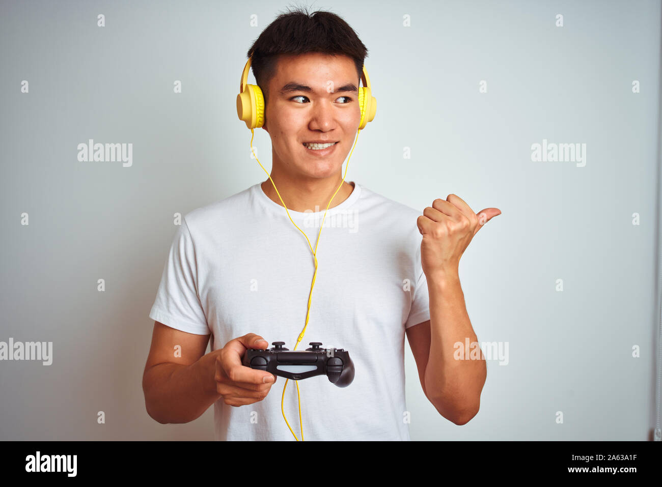 Young asian chinese gamer man playing video game standing over isolated ...