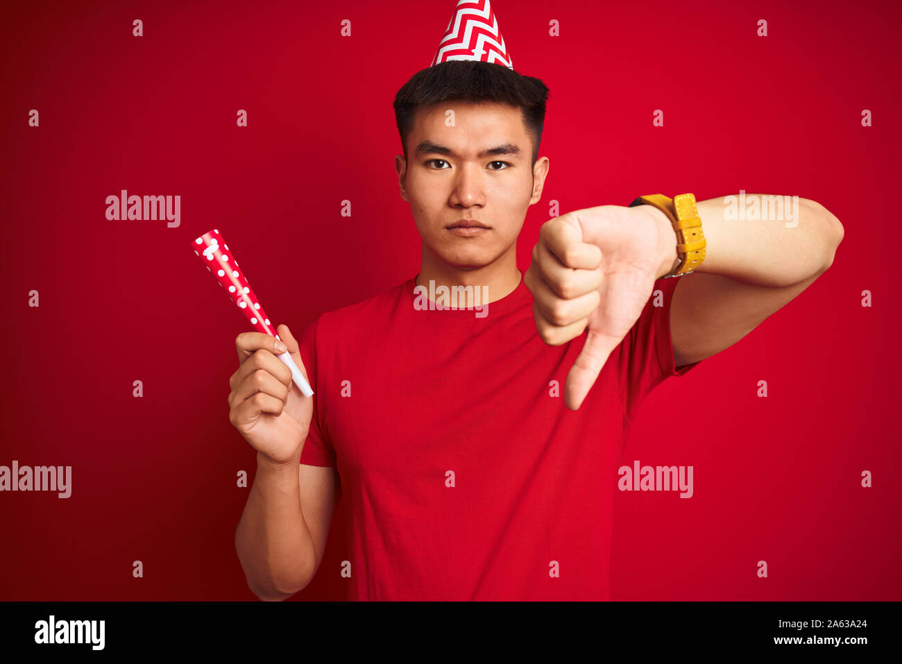 Asian chinese man on birthday celebration wearing funny hat over ...