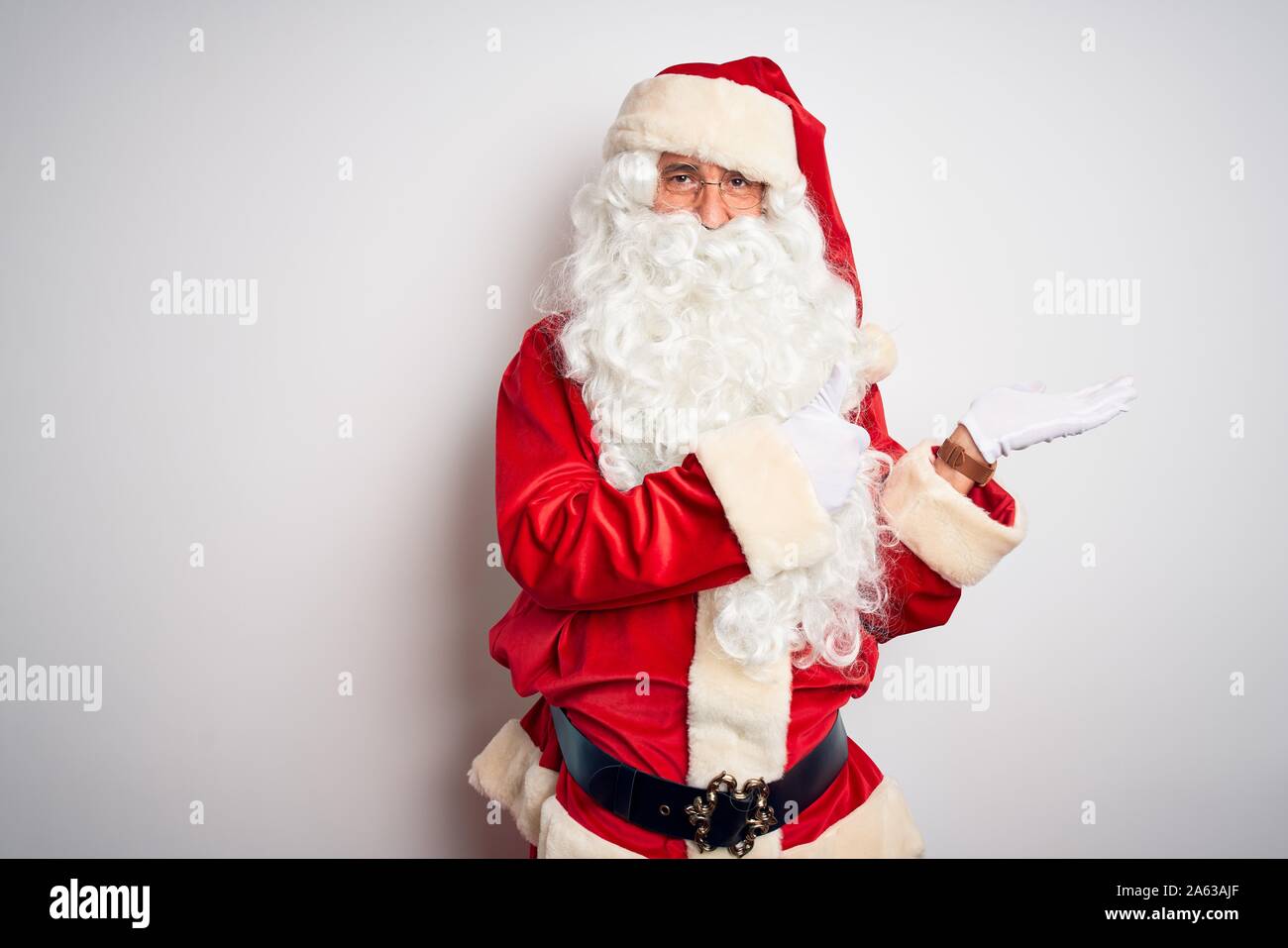 Middle age handsome man wearing Santa costume standing over isolated ...