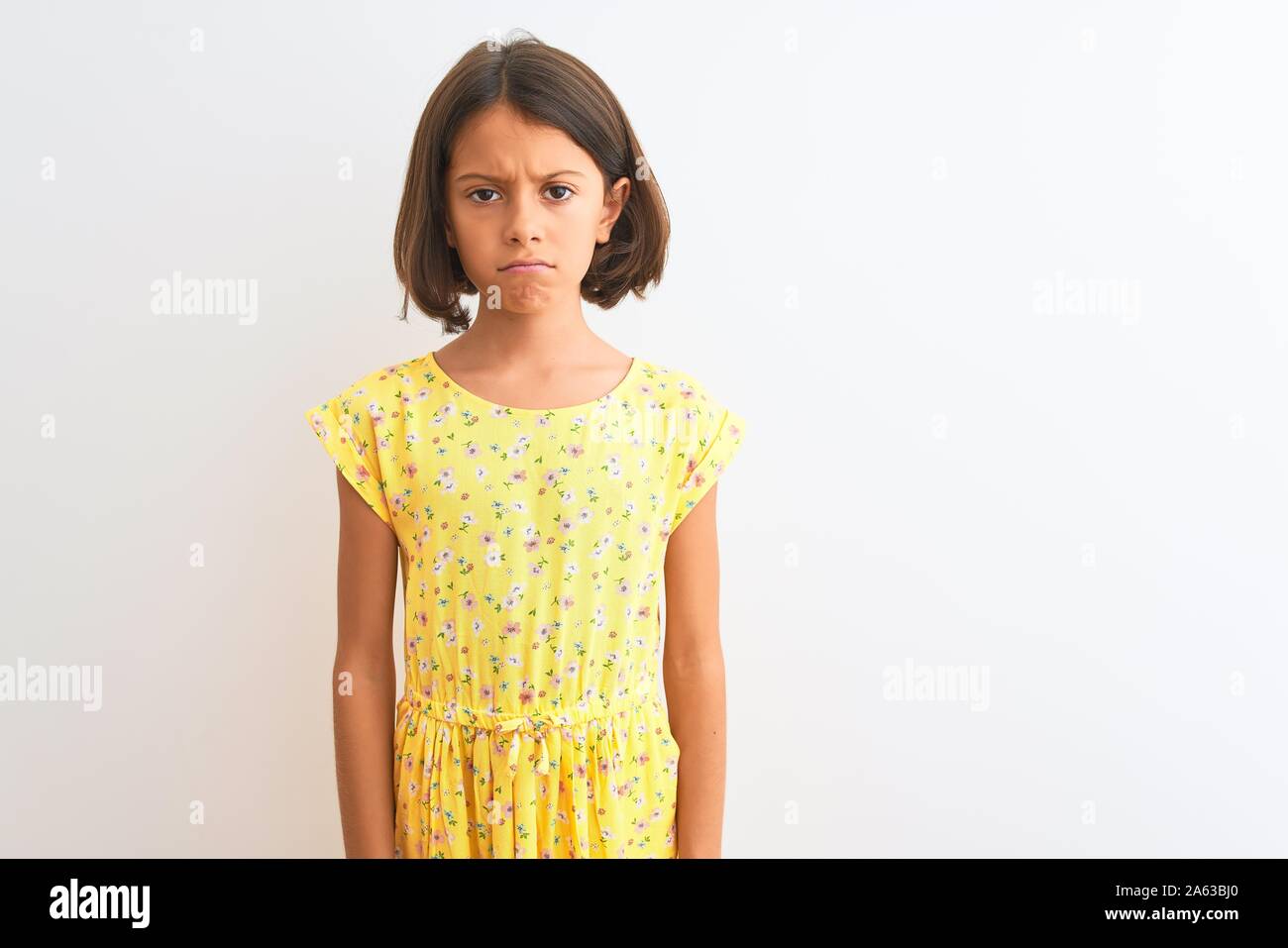 Young beautiful child girl wearing yellow floral dress standing over ...