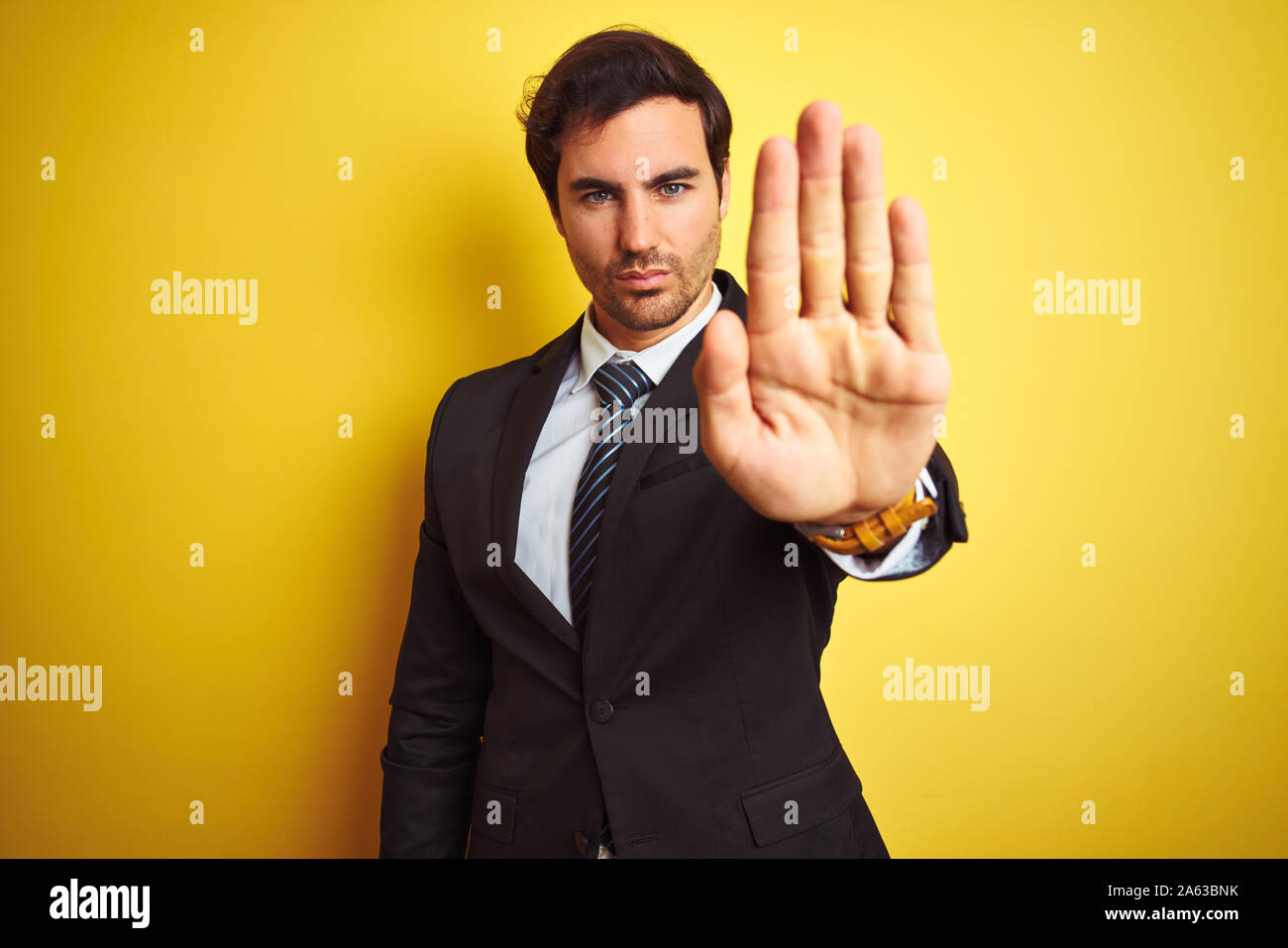 Young handsome businessman wearing suit and tie standing over isolated ...