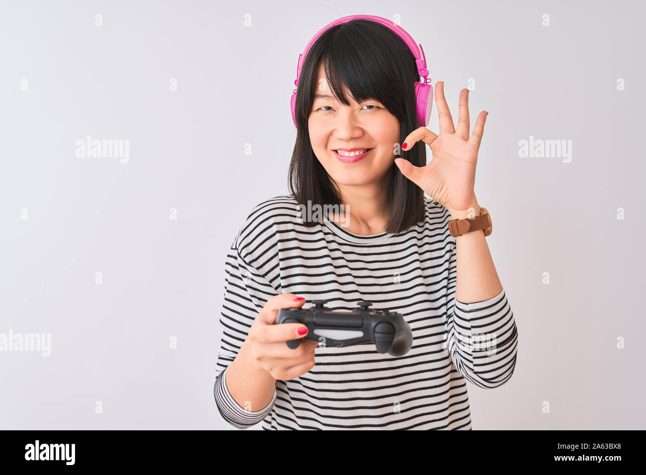 Chinese gamer woman playing video game using headphones over isolated ...
