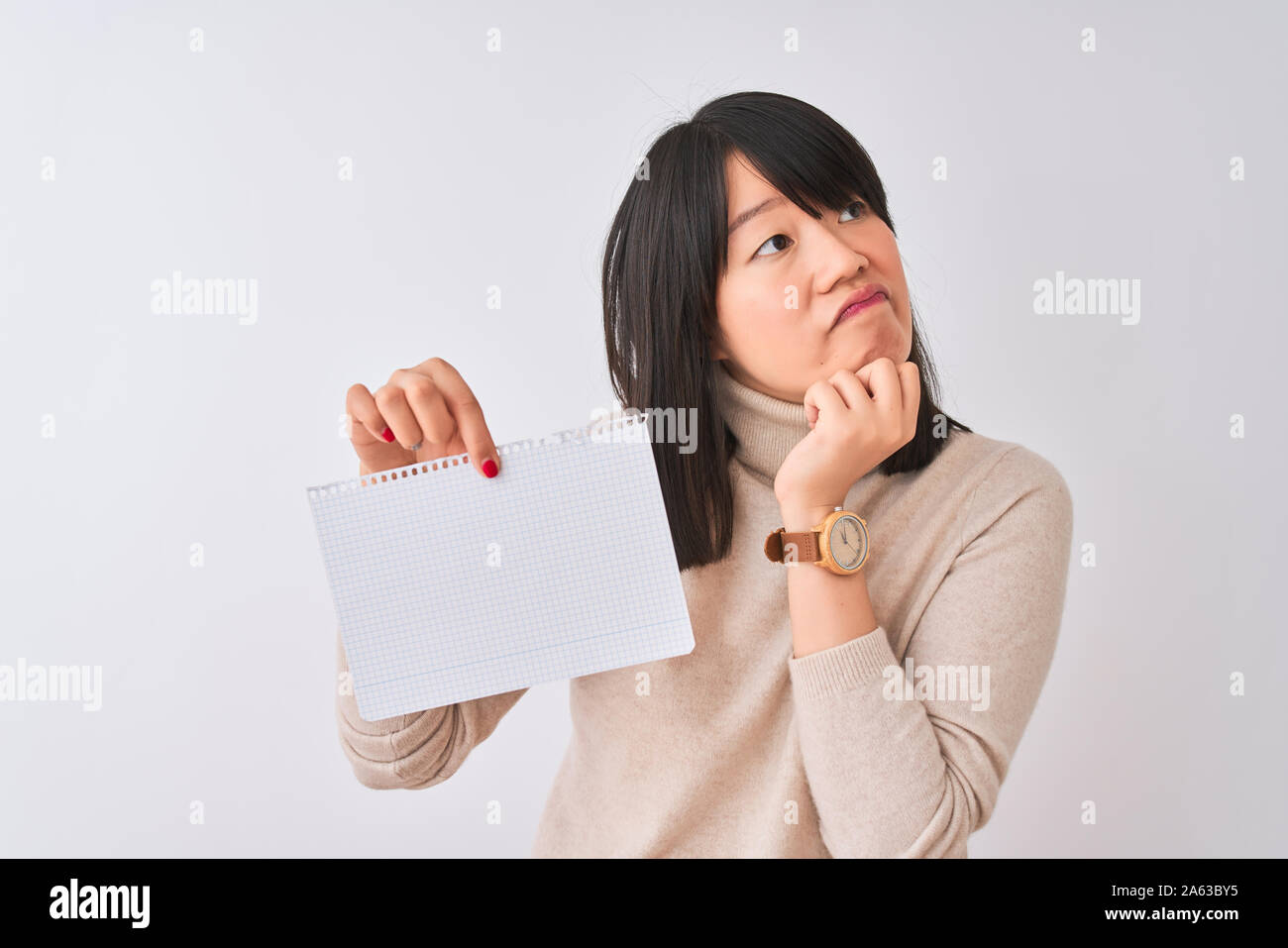 Young beautiful chinese woman holding notebook over isolated white ...