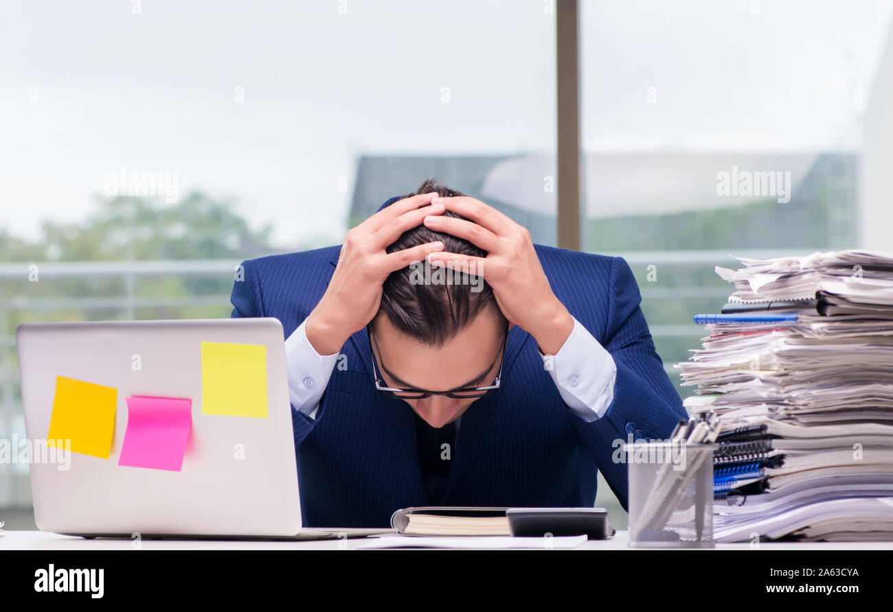 The workaholic businessman overworked with too much work in office ...