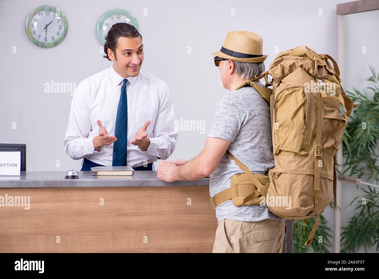 Old backpacker at the hotel reception Stock Photo - Alamy