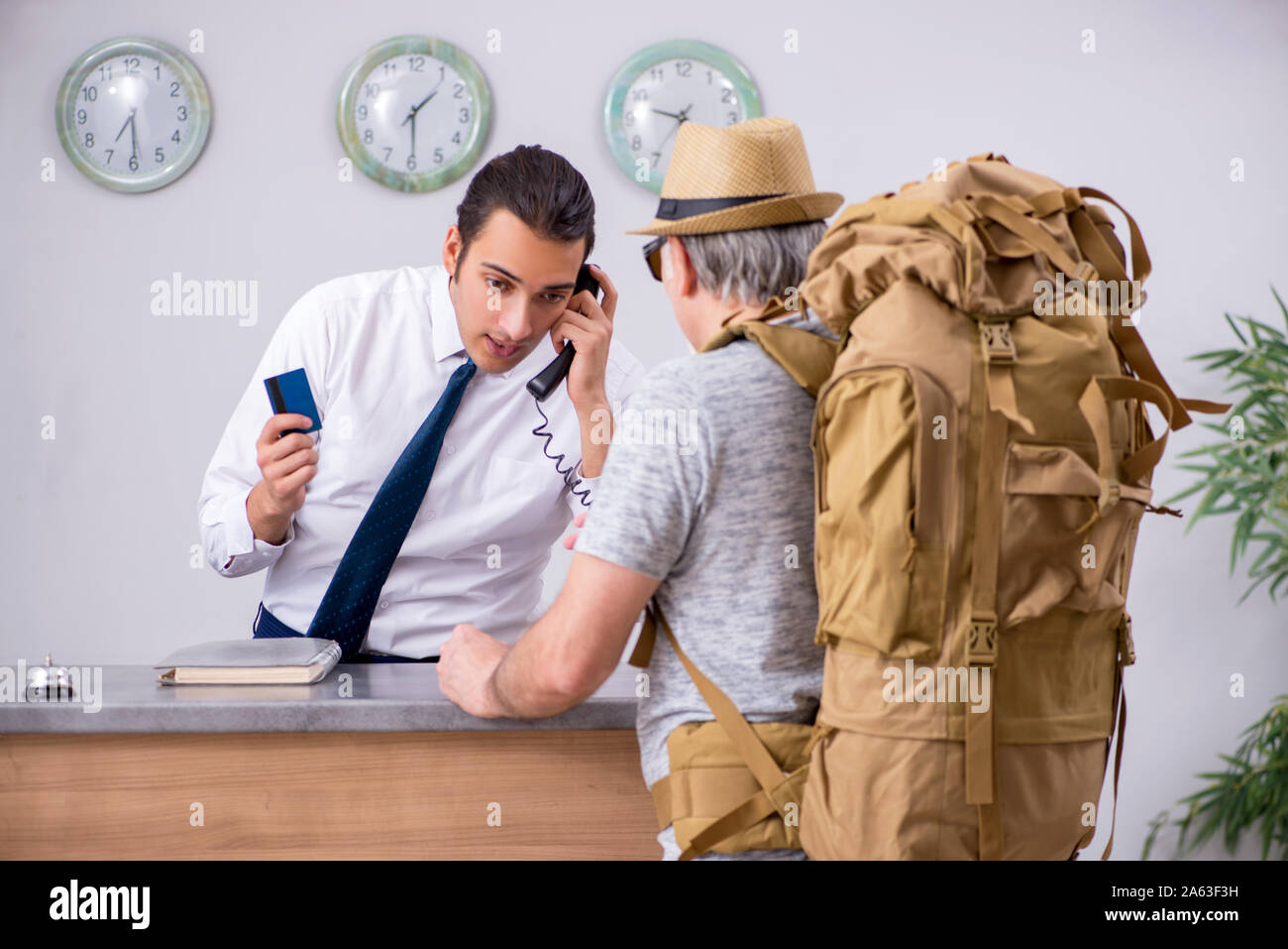 Old backpacker at the hotel reception Stock Photo - Alamy