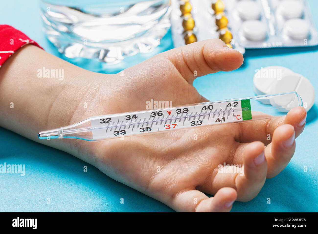 Treatment for high fever in children. Thermometer in the hand of a ...