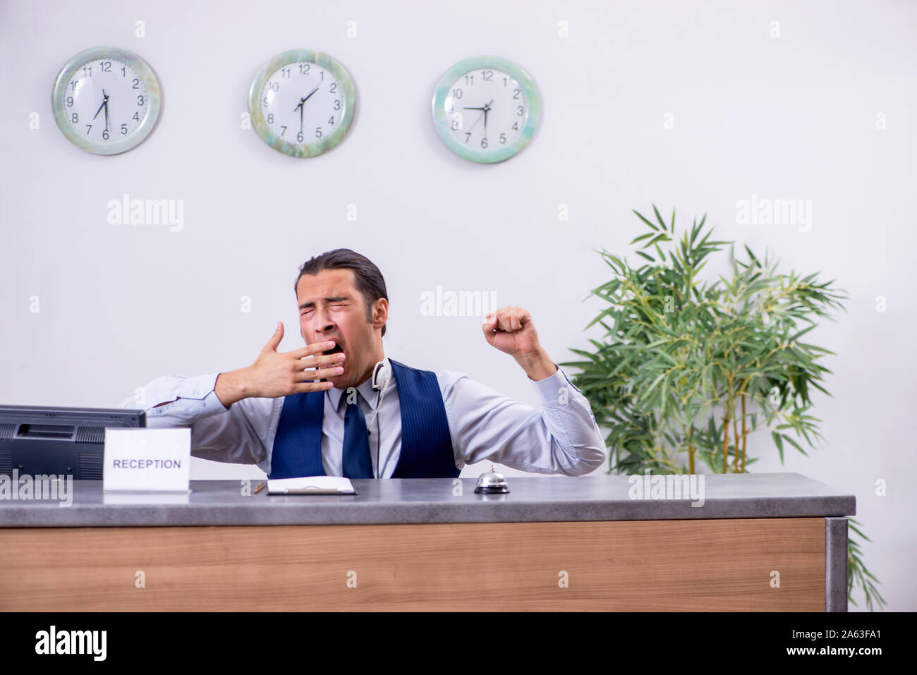 The young man receptionist at the hotel counter Stock Photo - Alamy