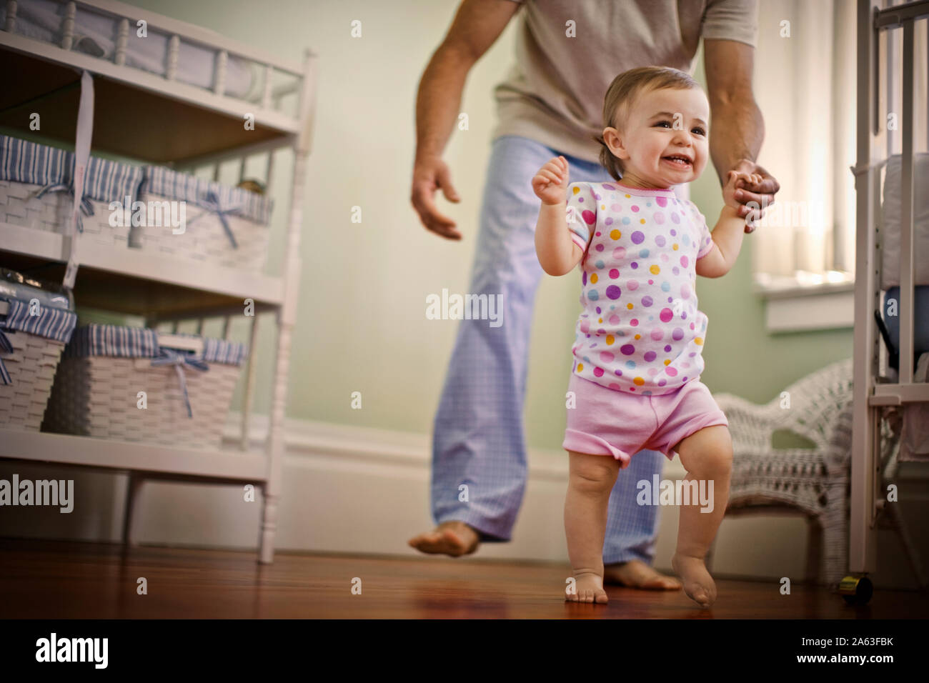 Father helping his baby daughter take her first steps Stock Photo - Alamy
