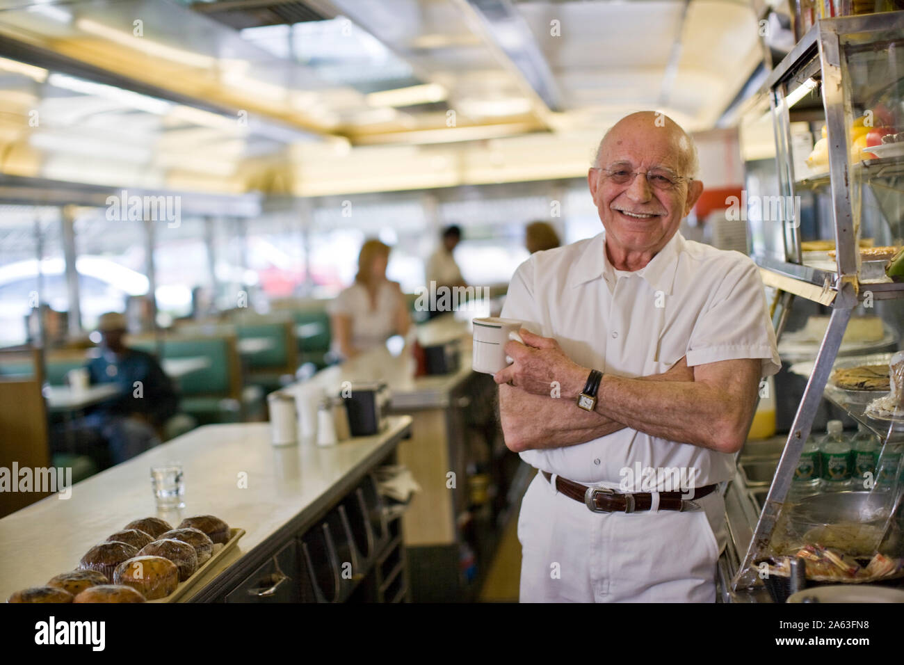 Man standing in old fashioned diner behind counter Stock Photo - Alamy
