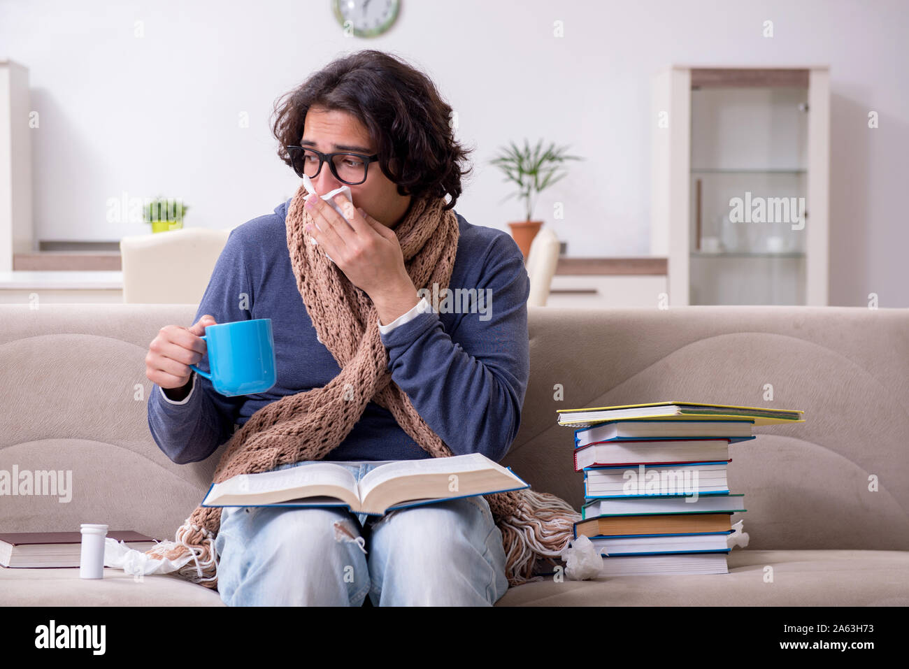 The sick male student suffering at home Stock Photo - Alamy