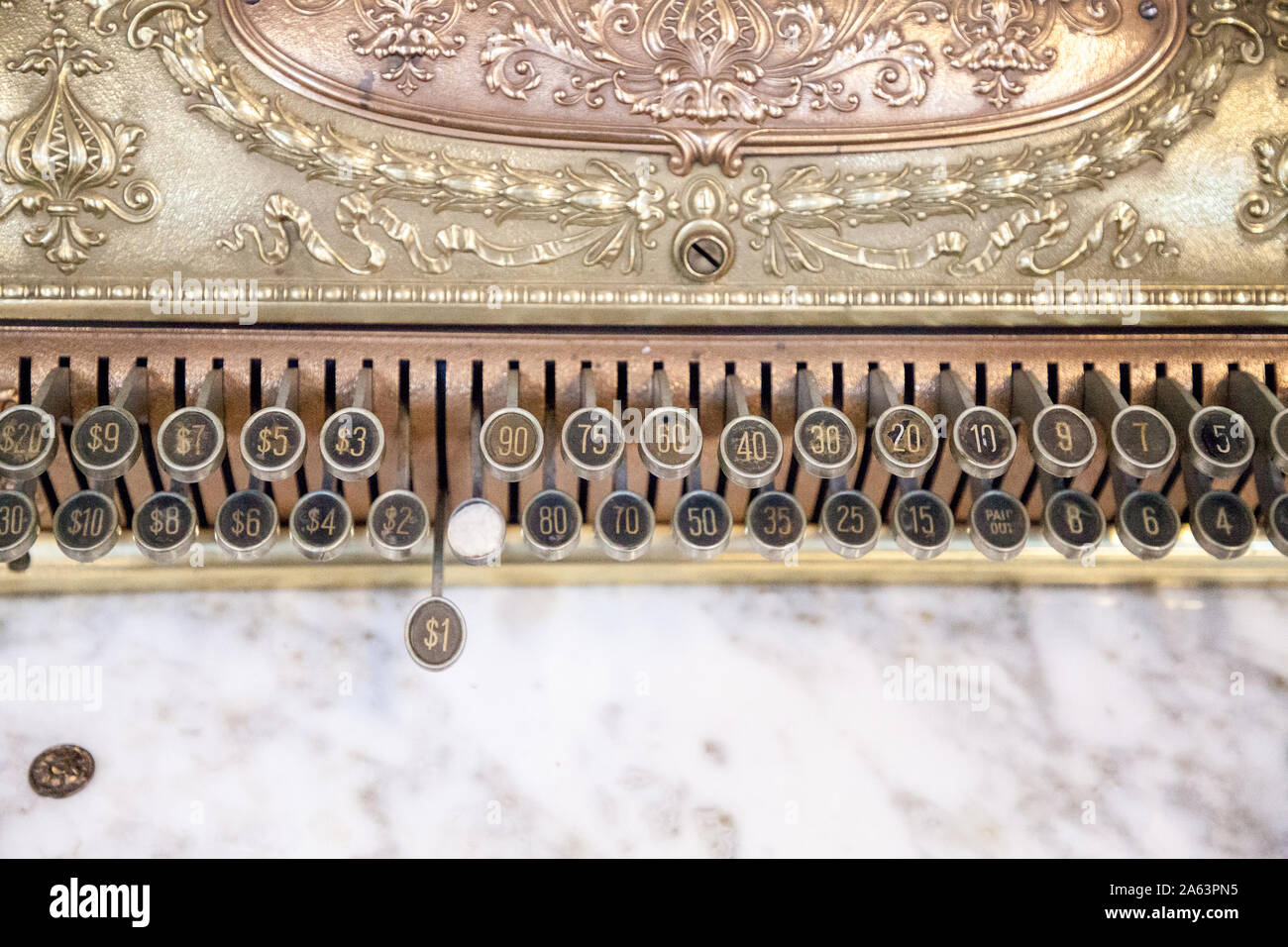 Gold and marble colored antique cash register with large gold keys and ...