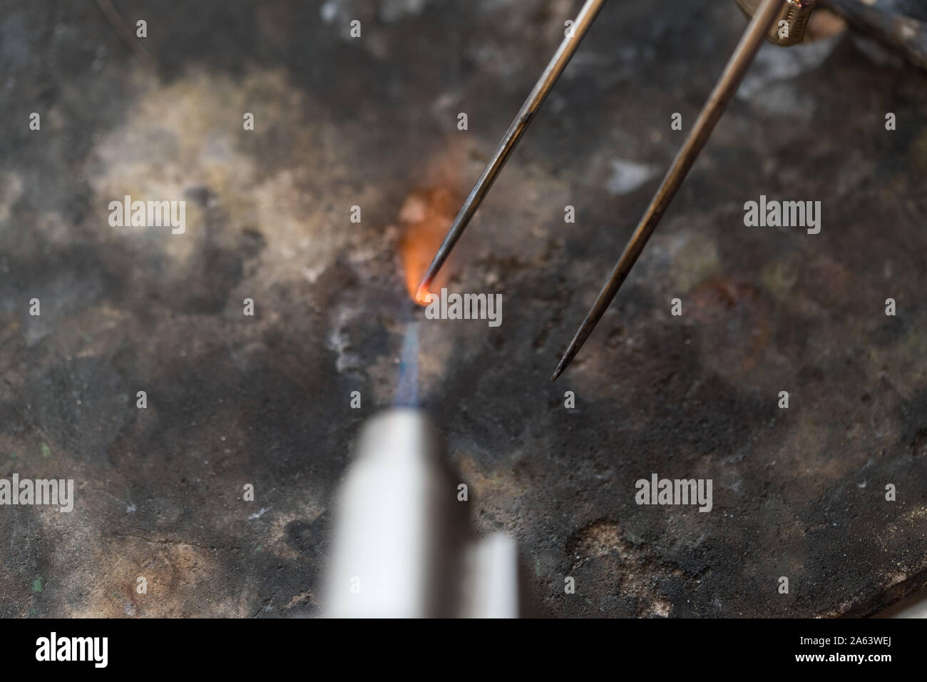 Goldsmith Hand Holds A Golden Ring On The Wooden Workbench And Works On ...