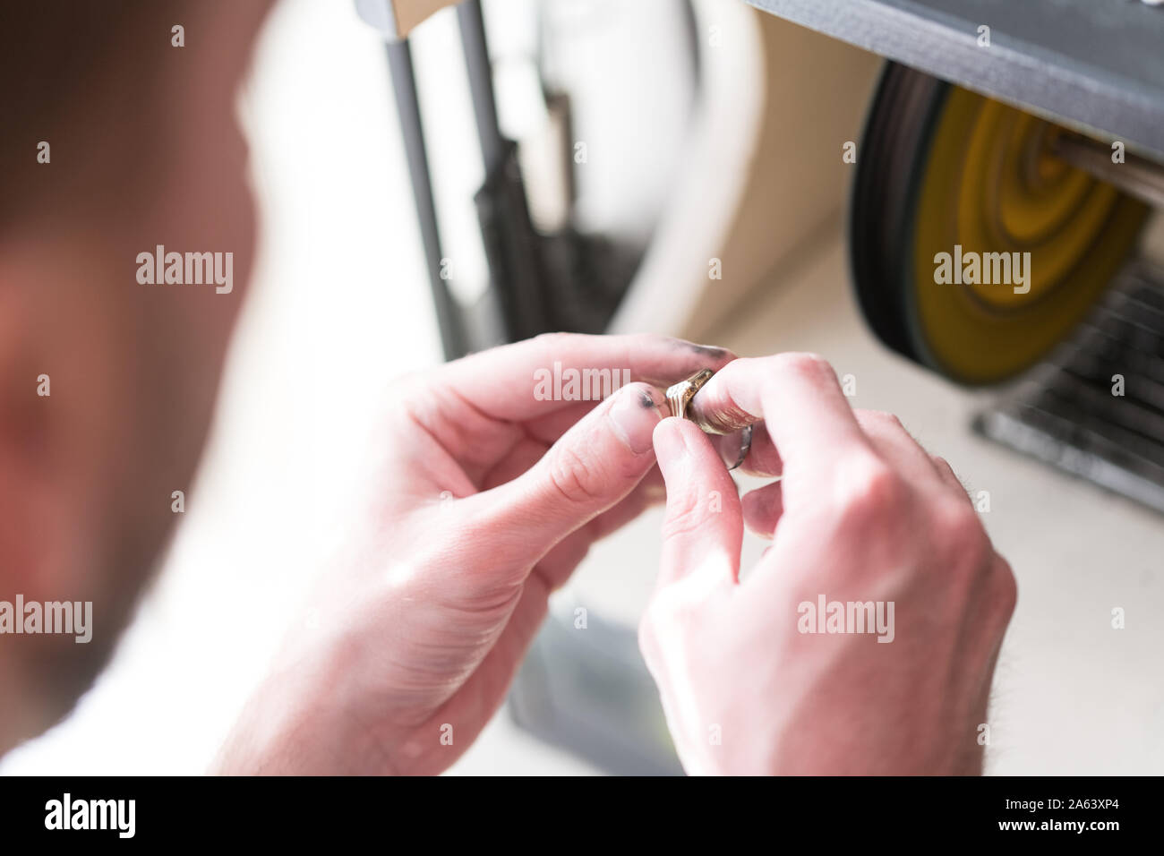 Jeweler Polishing A Gold Ring At Workbench - Goldsmith Making A Ring At ...