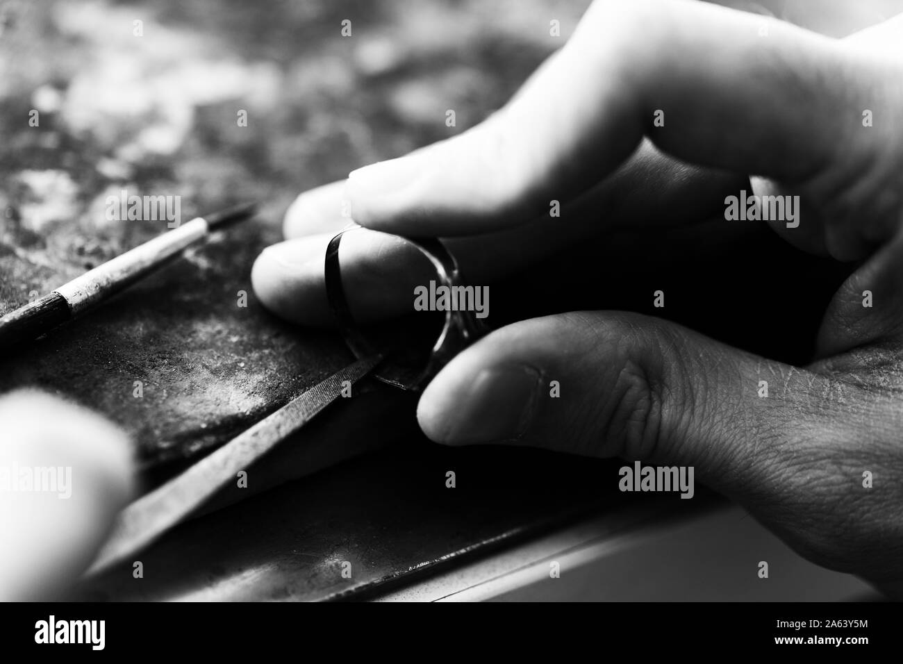 Hardworking Goldsmith Working On An Unfinished Gold Ring With His Hands ...