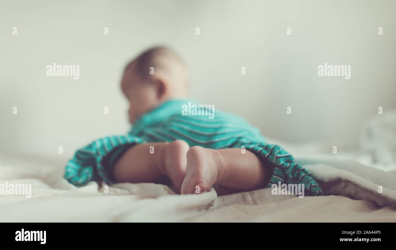 Cute baby boy rolling on bed and playing at home Stock Photo - Alamy