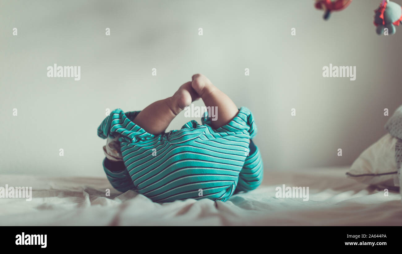 Cute baby boy rolling on bed and playing at home Stock Photo - Alamy