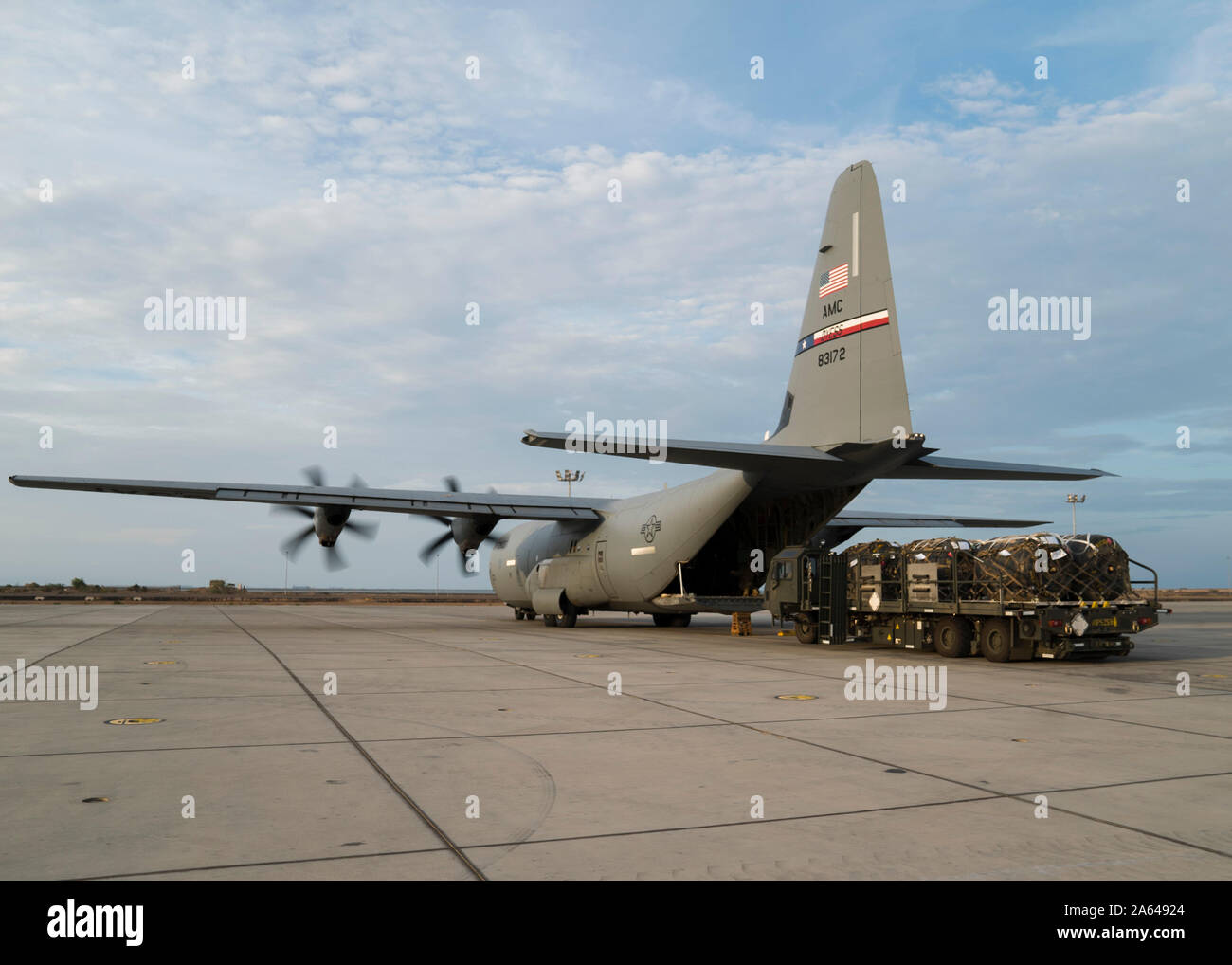 A K-loader approaches the rear loading ramp of a C-130J Super Hercules ...