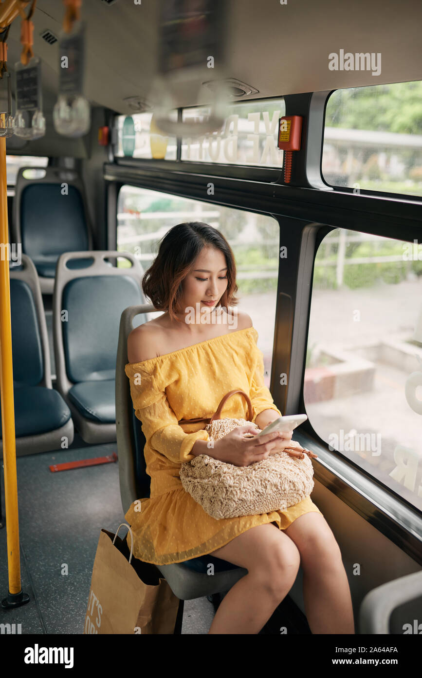 young beautiful asian woman browsing and typing messages in a public ...