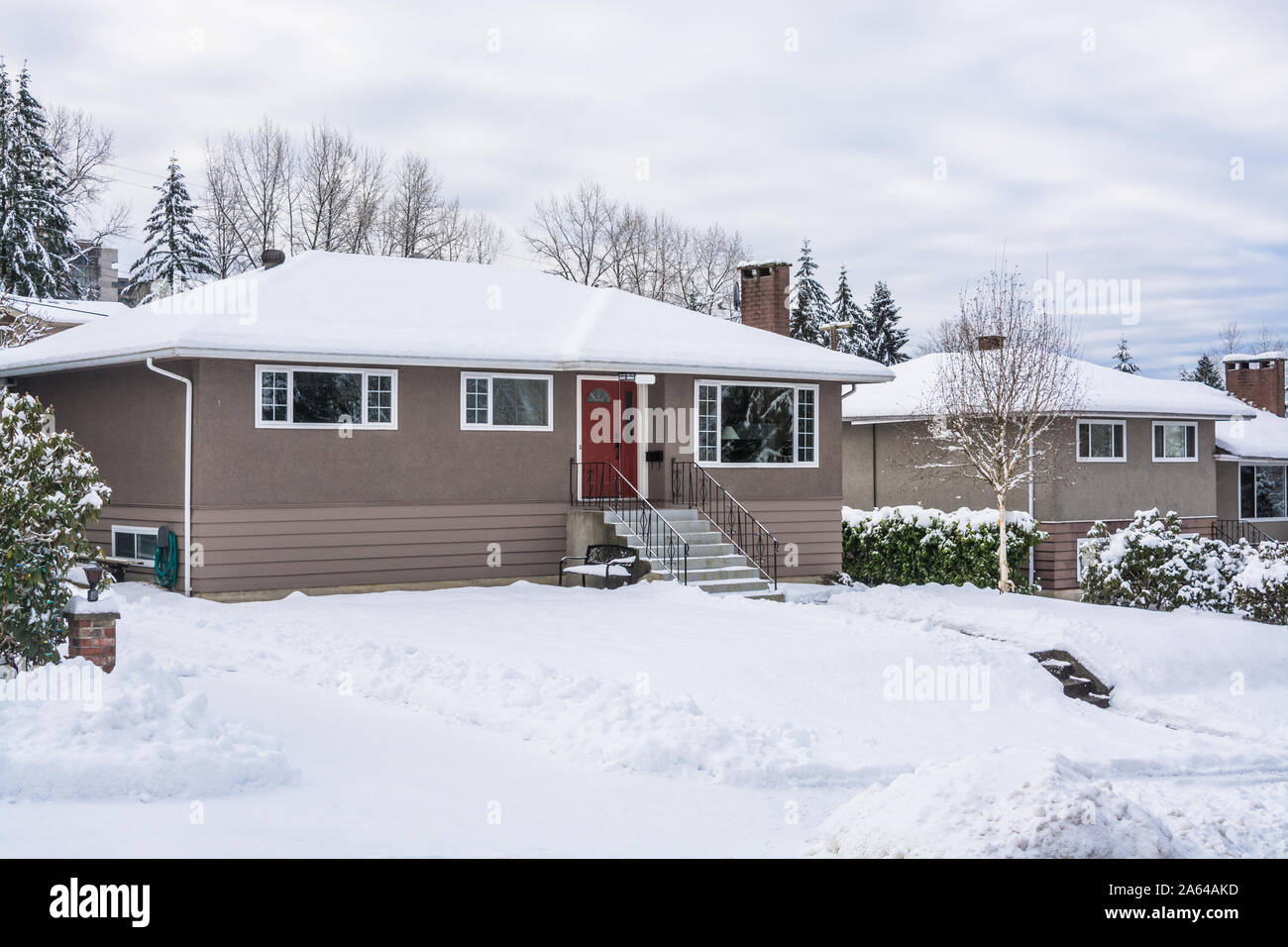 Family residential house with front yard in snow on winter cloudy day ...