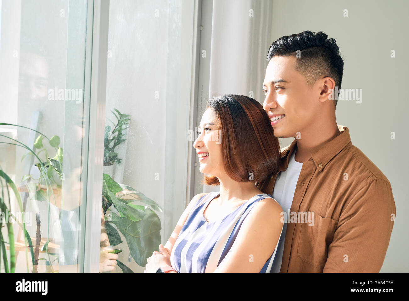 Happy couple standing window hi-res stock photography and images - Alamy
